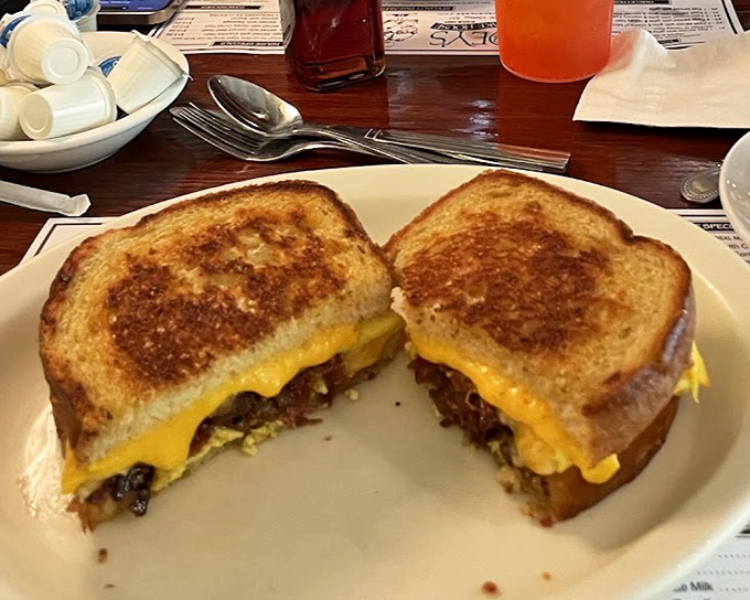 A breakfast sandwich cut to reveal its secrets&mdash;like a delicious archaeological dig revealing layers of morning happiness between perfectly toasted bread.