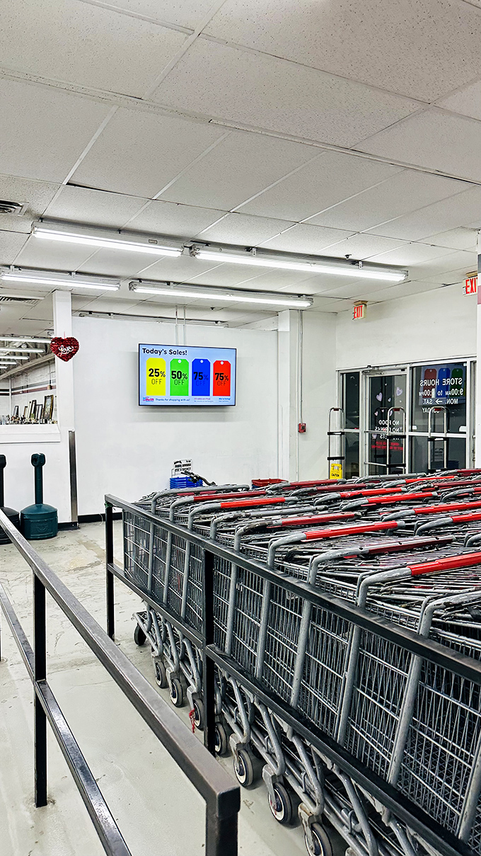 Shopping carts await their next adventure, while a digital display announces today's color-coded discounts&mdash;thrifter's version of winning lottery numbers.