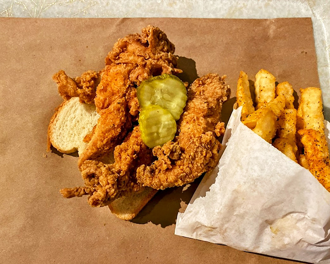 A chicken sandwich with pickles that's dressed for success on brown paper—no plates needed when the food is this honest and delicious.