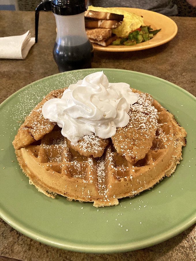 A Belgian waffle crowned with powdered sugar and cloud-like whipped cream&mdash;breakfast royalty that makes you feel like you've won the morning lottery.