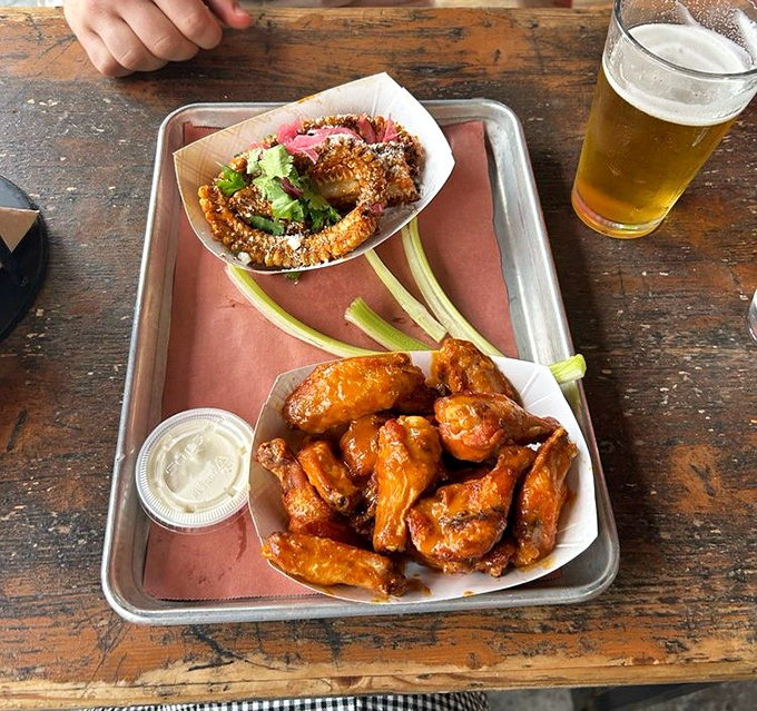 Wings and onion rings sharing a tray like old friends at a reunion &ndash; crispy, saucy, and ready to disappear faster than fog in sunshine.