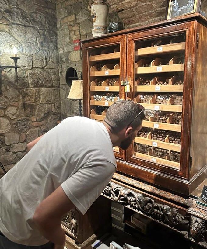A gentleman examines the cigar selection with the focused concentration usually reserved for choosing Netflix shows.