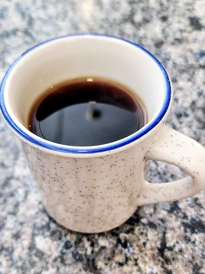 Their coffee comes in mugs designed for serious sipping, not dainty teacups – the blue rim a signature touch.