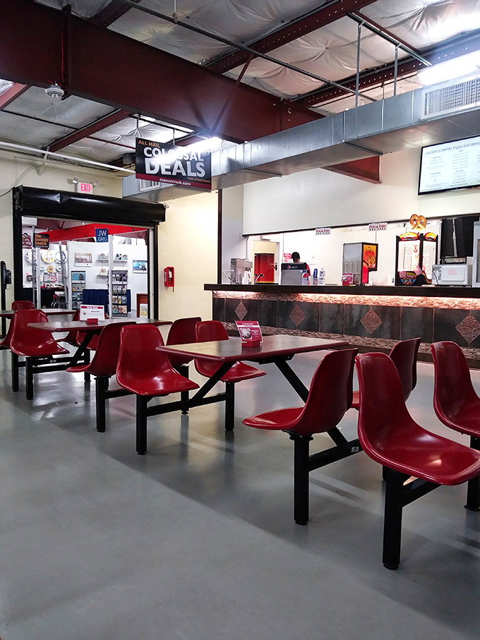 The food court offers a moment of respite for weary shoppers, with those red chairs practically shouting "sit down and refuel before round two!"