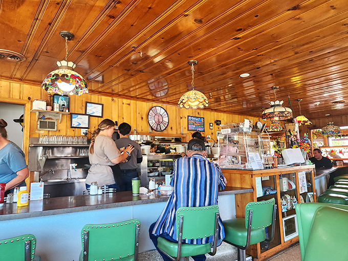 The counter offers front-row seats to the breakfast show, with turquoise stools that have witnessed countless coffee refills and morning conversations.