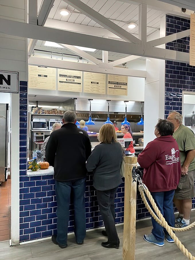 The ordering counter, with its nautical blue tile backdrop, where seafood dreams begin and hungry patrons line up with anticipation.