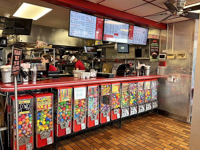 The counter view reveals the secret weapon: those candy machines lining the front, ensuring your sweet tooth gets equal billing with your savory cravings.