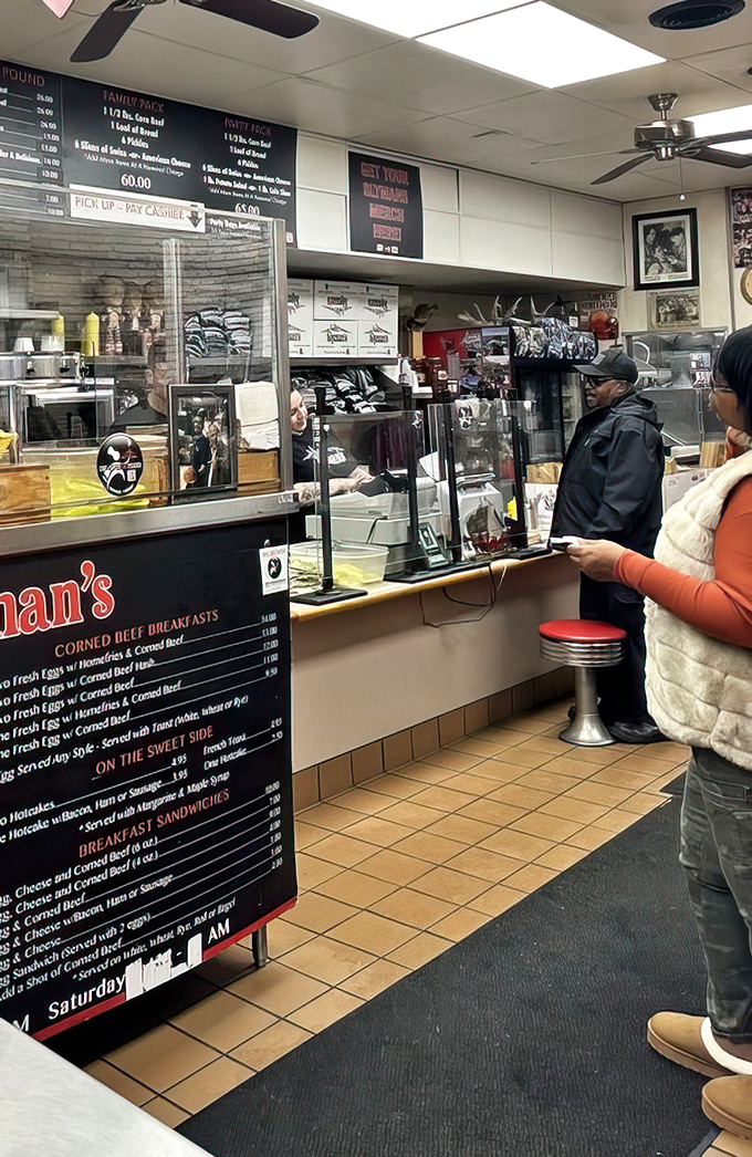 The counter where sandwich magic happens, with customers patiently waiting for their turn at Cleveland's deli greatness.