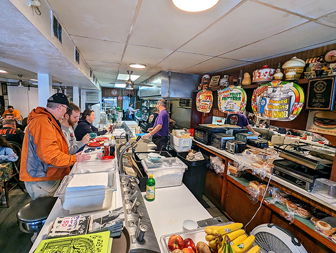 Behind the counter, breakfast magic happens while regulars watch the morning ballet of spatulas and coffee pots.