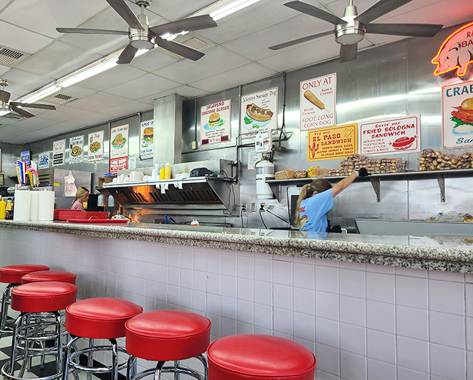 The counter seating offers front-row tickets to the culinary show. Red stools await hungry patrons like a diner version of Broadway.