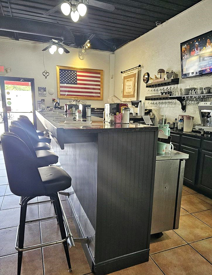 The counter seating area offers front-row tickets to the breakfast show, with an American flag proudly displayed and coffee always at the ready.