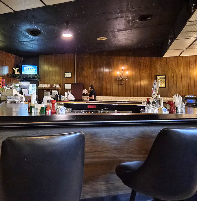 The bar area, with its classic wood paneling, feels like stepping into a time machine to when conversations happened face-to-face over cold drinks.