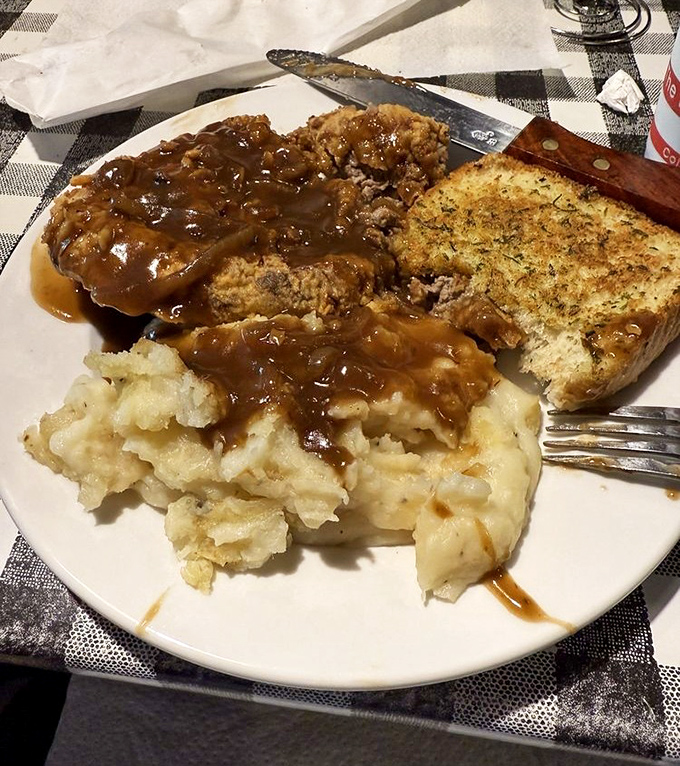 Country fried steak swimming in gravy with a side of mashed potatoes &ndash; comfort food that hugs you from the inside out.