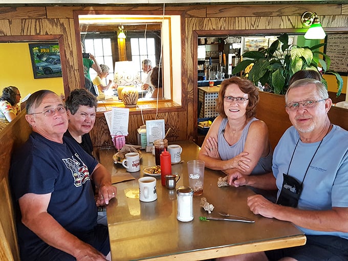 Happy diners sharing stories over steaming mugs&mdash;this is where memories are made between bites of comfort food classics.