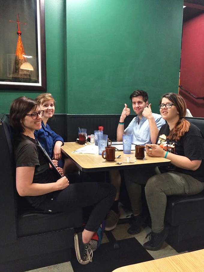 Friends gathered around a booth sharing laughs and meals perfectly captures what makes diner culture so enduringly wonderful.