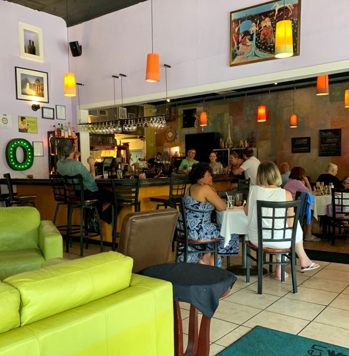 Happy diners gather at the bar, proving that good food creates community faster than anything else in the world.