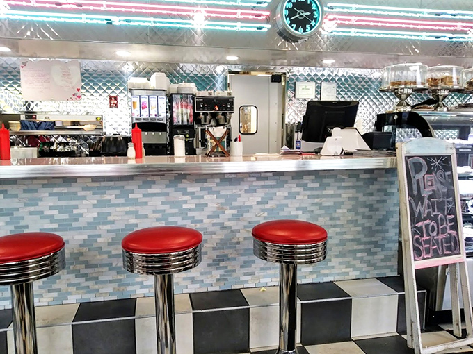 The counter where regulars become family and first-timers become regulars. Those red stools have heard decades of stories.