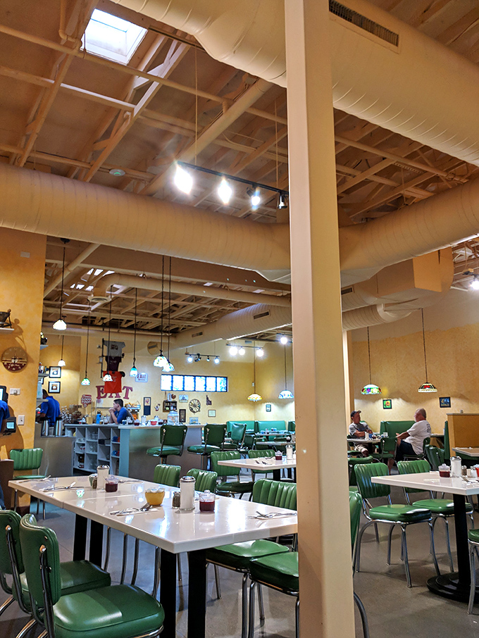 High ceilings, warm lighting, and those signature green chairs create the perfect breakfast sanctuary. Conversation and coffee flow freely here.