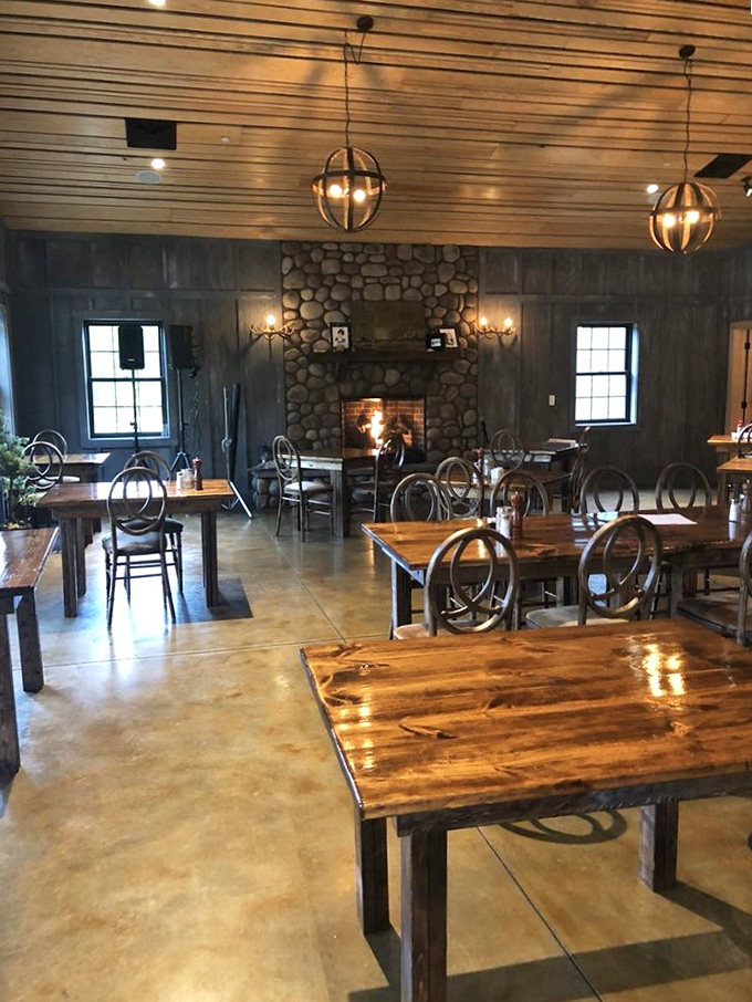 Stone fireplace anchoring this rustic dining room &ndash; because nothing complements wild game like the primal comfort of dancing flames.
