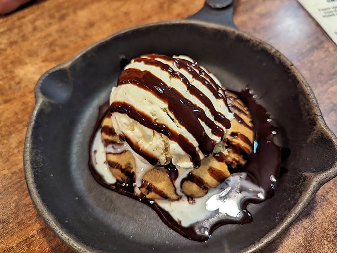 A cast-iron skillet of warm cookie topped with ice cream and chocolate drizzle—because after conquering Mount Barbecue, you deserve a sweet victory celebration.