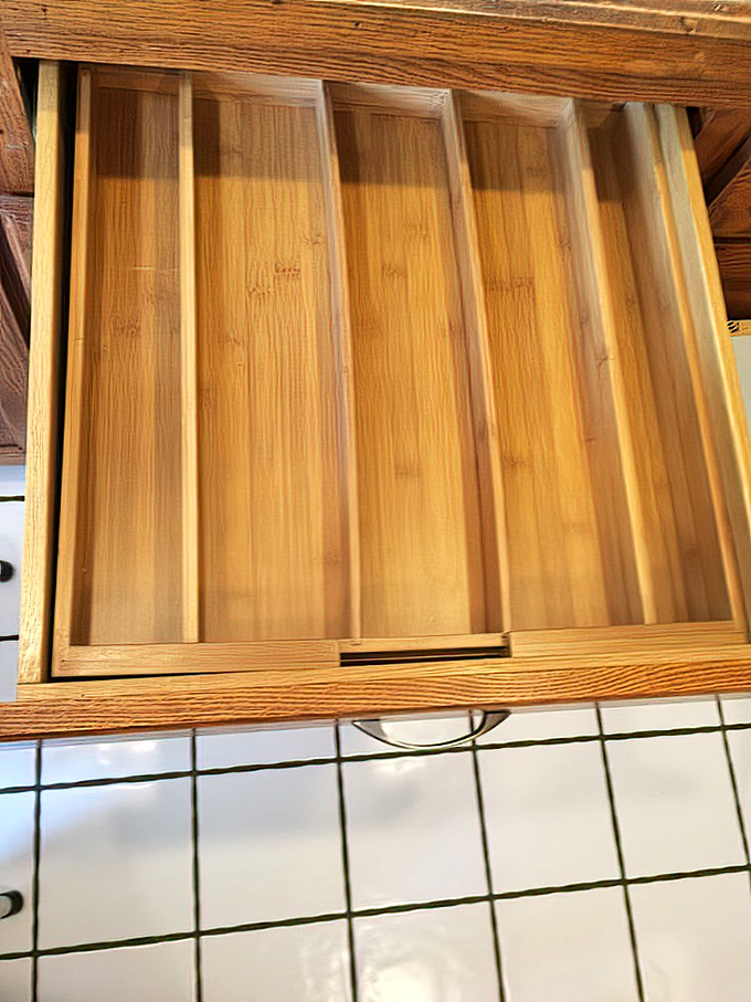 This bamboo drawer organizer waits patiently for someone to recognize its potential beyond mere utensil separation.