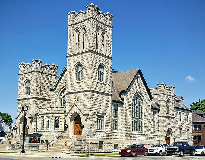 First Presbyterian Church stands like a limestone fortress of faith, its Gothic towers reaching skyward with the confidence of tax-free status.