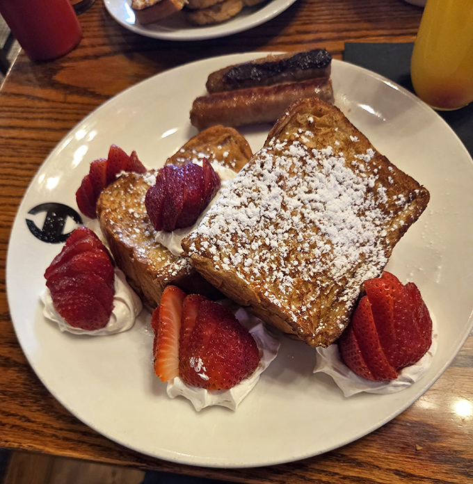 French toast that makes breakfast feel like dessert, dusted with powdered sugar and surrounded by berries that add just enough virtue to justify indulgence.