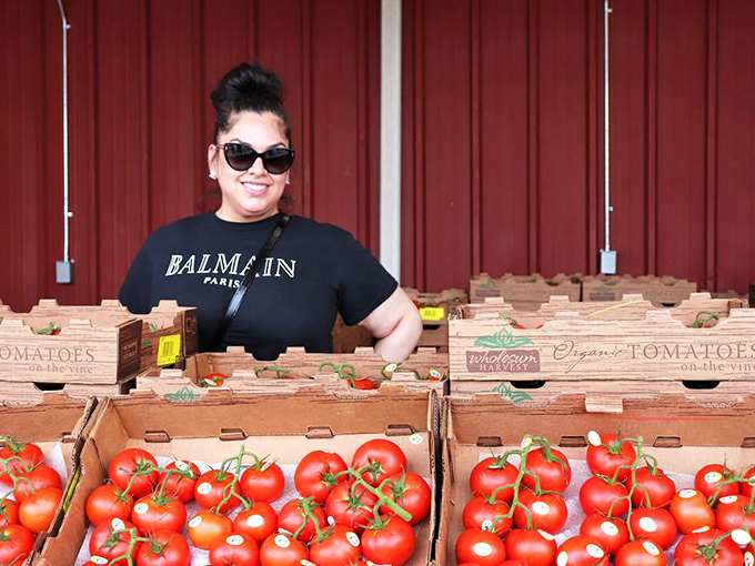 Fresh tomatoes stacked in wooden crates outside, because great markets know produce deserves prime real estate and sunshine.
