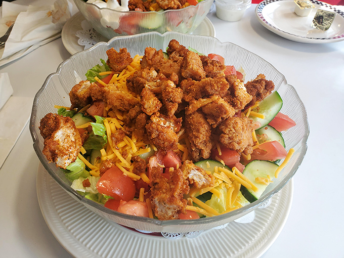 Crispy chicken perched atop a garden of fresh vegetables and cheese&mdash;proof that "salad" can be both virtuous and indulgent.