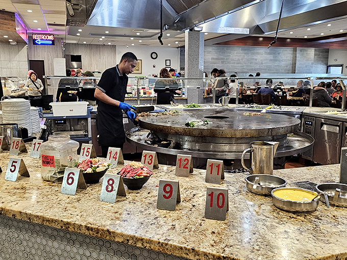 The Mongolian grill master at work &ndash; part chef, part performer, all wizard. Those numbered stations organize the chaos into a beautiful culinary ballet.
