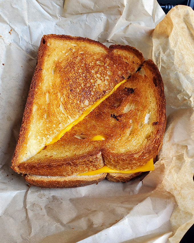 Golden-brown grilled cheese achieving that perfect cheese pull moment we all secretly live for.