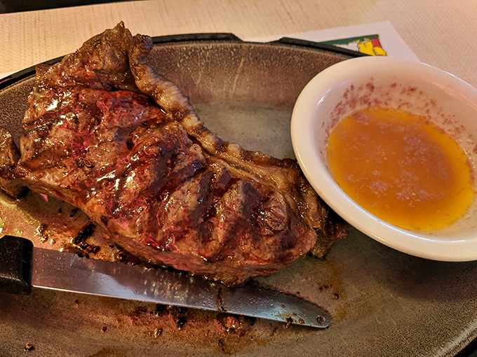 A steak that's been kissed by flame and seasoned by someone who understands restraint. That dipping sauce is just showing good manners.