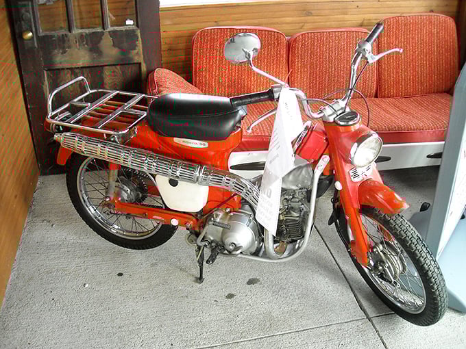 The bright red Honda 90 isn't just transportation; it's bottled freedom from simpler times. Easy Rider vibes for the sensible Midwesterner.