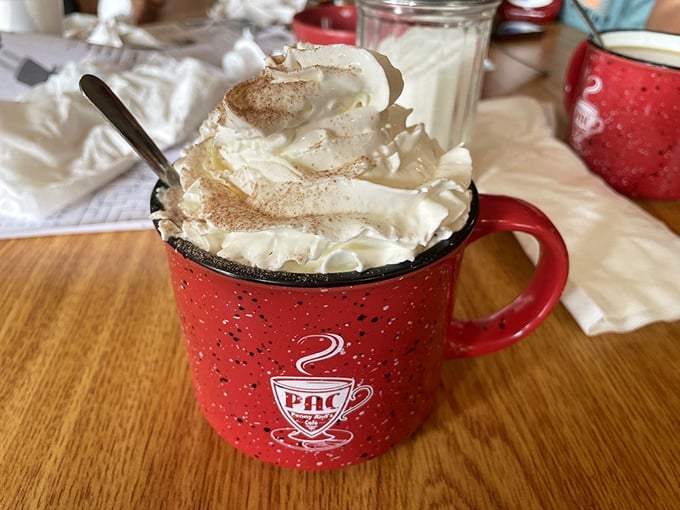 Hot chocolate that's dressed for success with a whipped cream hat. This isn't just a beverage; it's dessert in a signature red mug.