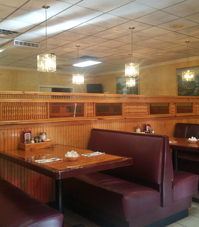 Booth seating with pendant lights creating intimate dining spaces where conversations flow as freely as coffee.