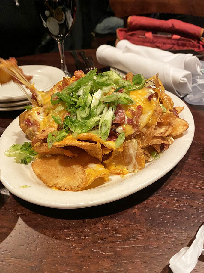 Irish Kettle Chips arrive as a mountain of crispy, cheese-laden goodness, where each layer reveals new treasures of bacon and green onion.