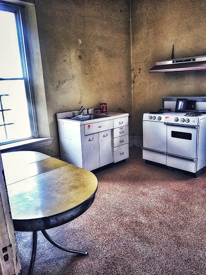 The kitchen where meals were once prepared now sits abandoned, its mid-century appliances like artifacts in a museum of everyday life.