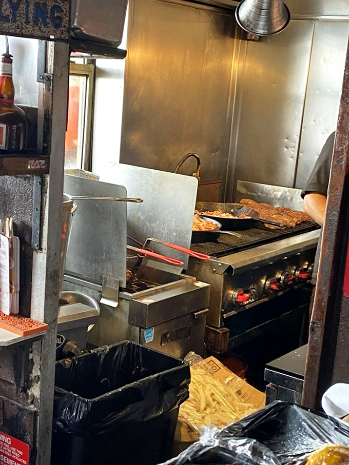 A glimpse into the kitchen reveals the sacred grill where burger magic happens &ndash; no fancy equipment, just fire and expertise.