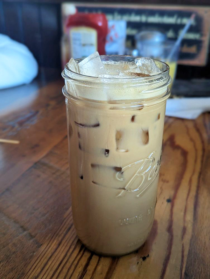 Iced latte served in a Mason jar, proving that even cowboys need their caffeine fix dressed down and ready to work.