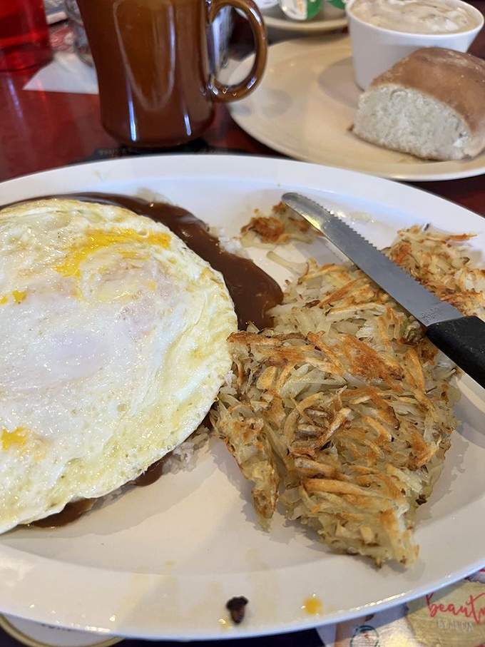 The perfect sunny-side up eggs stare back at you like optimistic eyes, while hash browns stand ready for their supporting role.