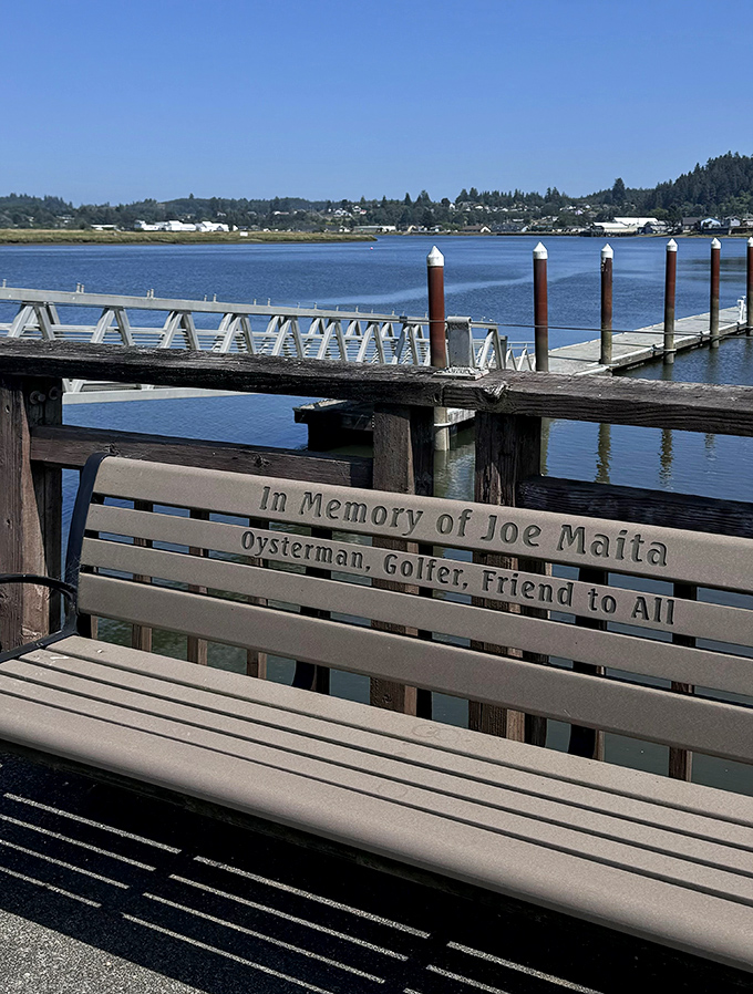 A memorial bench overlooks the bay, reminding visitors that real communities with real histories built this charming town.