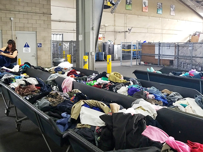 The backstage sorting area reveals thrifting's secret ingredient: human hands carefully evaluating each donation before it reaches the sales floor.