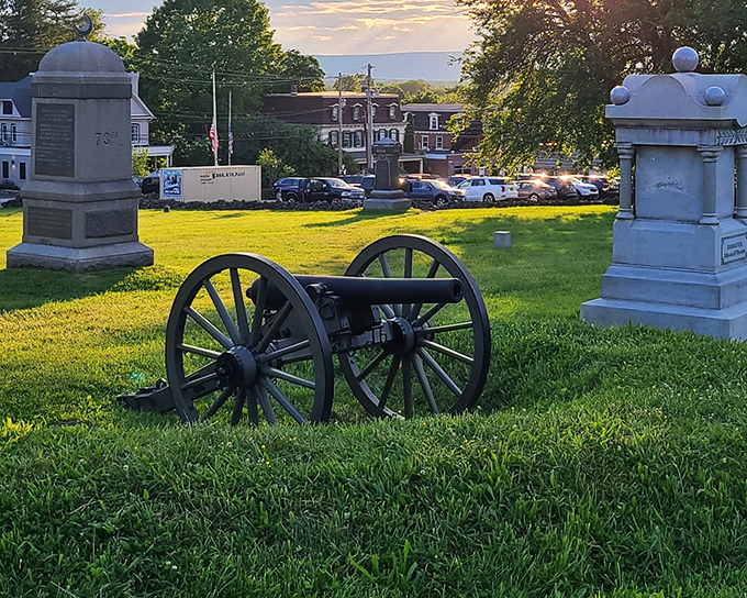 A Civil War cannon rests among monuments on the battlefield, a somber reminder of the artillery that once thundered across these now-peaceful fields.