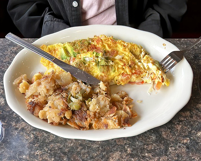 An omelet that's mastered the art of the fold, packed with colorful vegetables and paired with home fries that deserve their own fan club.