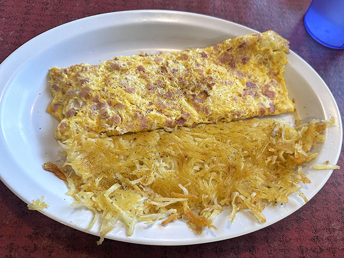 This omelet doesn't just contain ham&mdash;it's engaged in a loving relationship with those crispy hash browns on the side.