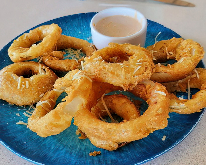 Onion rings with the ideal crunch-to-tender ratio, sprinkled with parmesan—proof that simple pleasures are often the most satisfying.