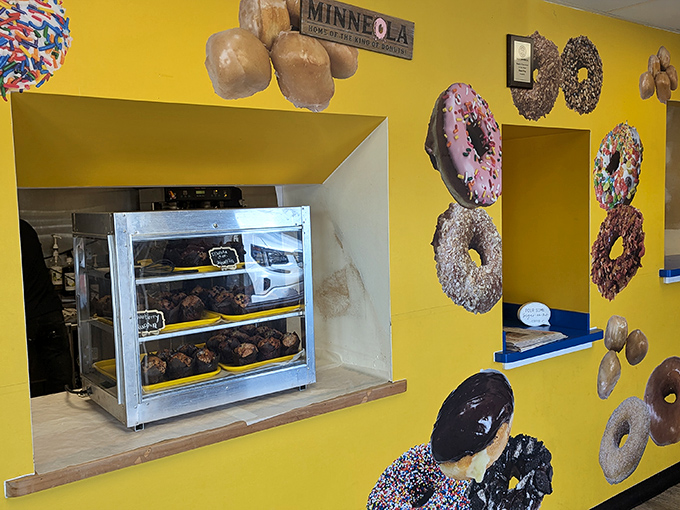 A Minneola sign watches over donut displays like a proud parent. This small town hit the culinary lottery with its crowned pastry king.