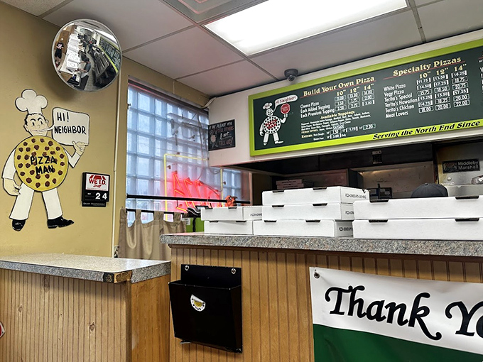 The ordering counter, where dreams and hunger meet. That vintage pizza man mascot has witnessed thousands of "I'll take a large pepperoni" moments.
