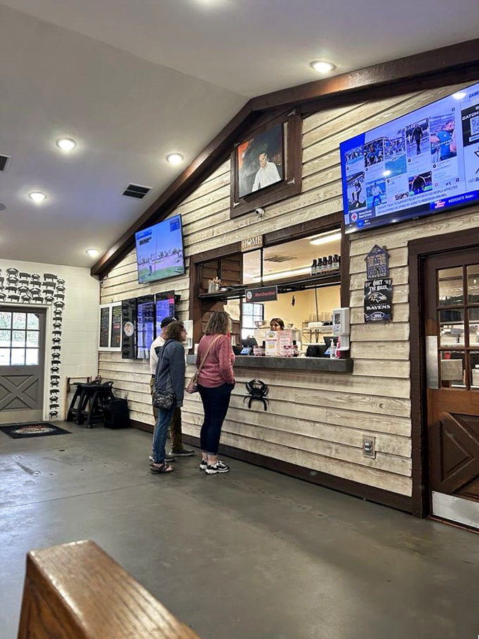 The ordering counter feels like a friendly command center, where culinary dreams come true beneath the watchful gaze of multiple TV screens.