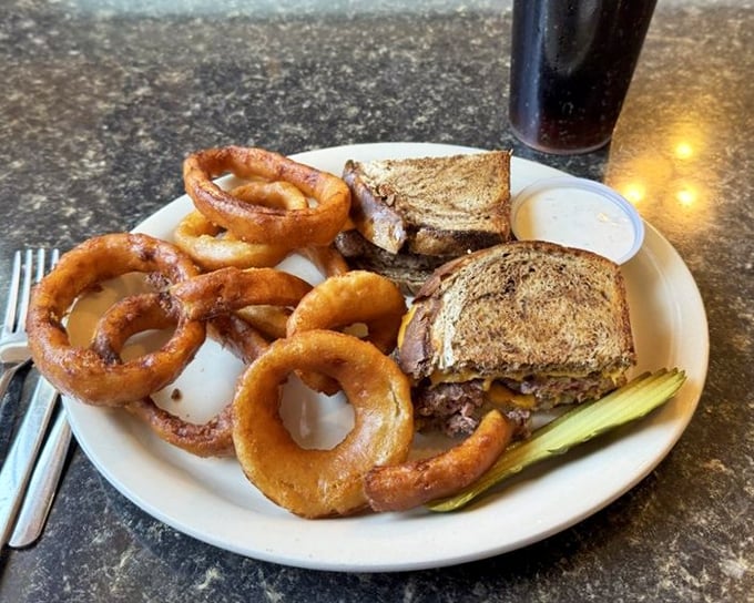 Onion rings with the perfect crunch-to-give ratio alongside a sandwich that makes no apologies for its delicious simplicity.